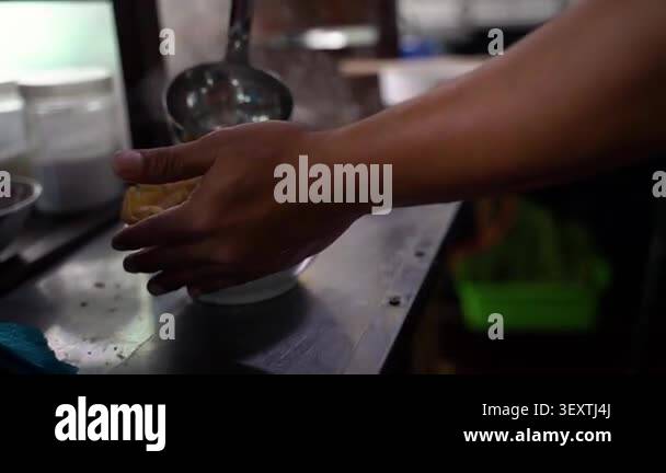 Close-up kitchen sequence shows hand plating prepared food in small ...