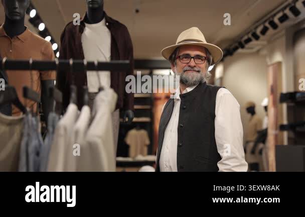 Stylish mature man with a beard and glasses smiling while shopping for ...