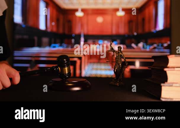 Judges hand hitting a gavel on a sounding block with a courtroom ...