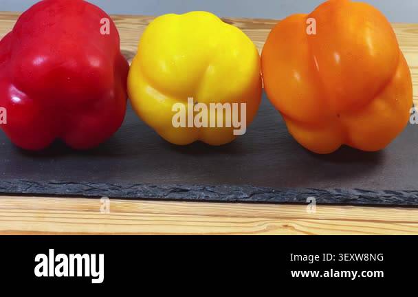 Multicolored bell peppers on flat black slate plate, side view Stock ...
