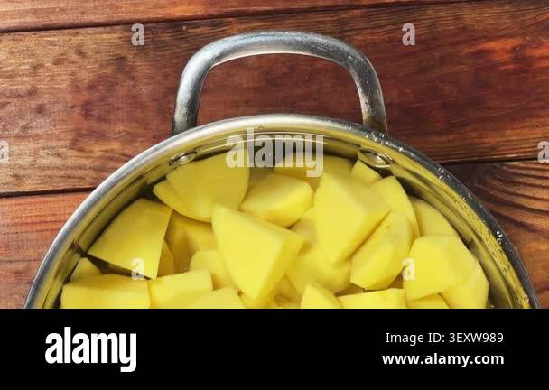 Raw potatoes pieces in pot with cold water, top view Stock Video ...