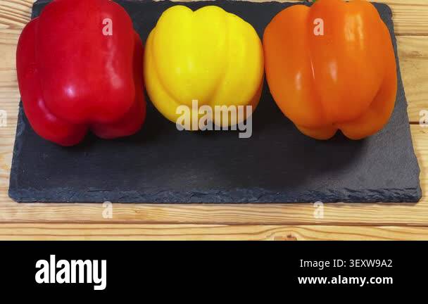 Multicolored bell peppers on a flat black slate serving plate Stock ...
