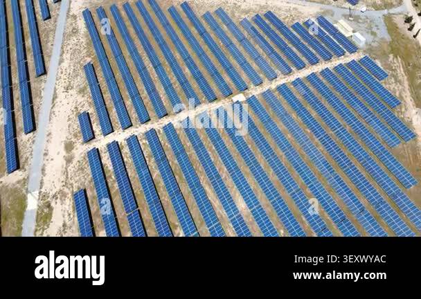 Drone view flying over a large solar farm power plant generating clean ...