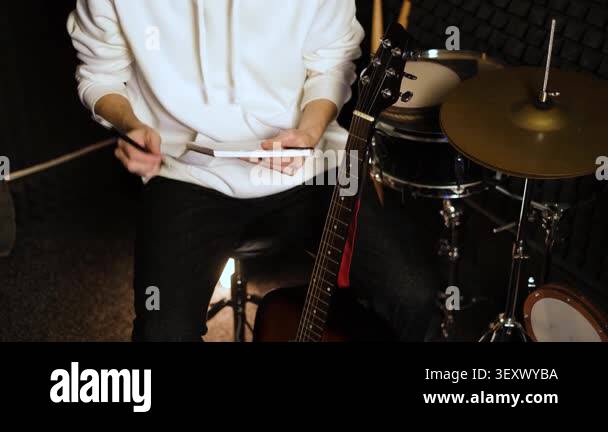 Young musician man writing lyrics for new song making notes in notebook ...