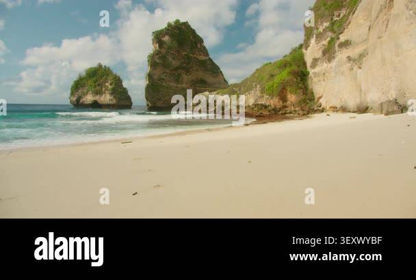 Woman jogging on white sand of Diamond Beach with cliffs and ocean in ...