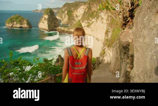 Rear view of woman looking at ocean and Diamond Beach cliff in Nusa ...