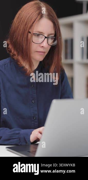 Woman types on a laptop in a workspace during daytime while focused on ...