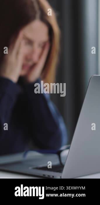 A woman types on a laptop while focused on her work in a cafe during ...