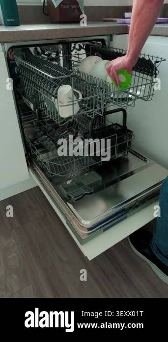 Clean dishwasher opens dishes are added. Buttons are pushed to start ...