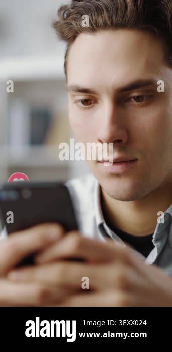 Man looks at smartphone with heart likes icons, showing emotions and ...
