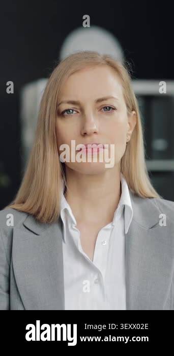A woman sits in an office holding her head, looking distressed during ...