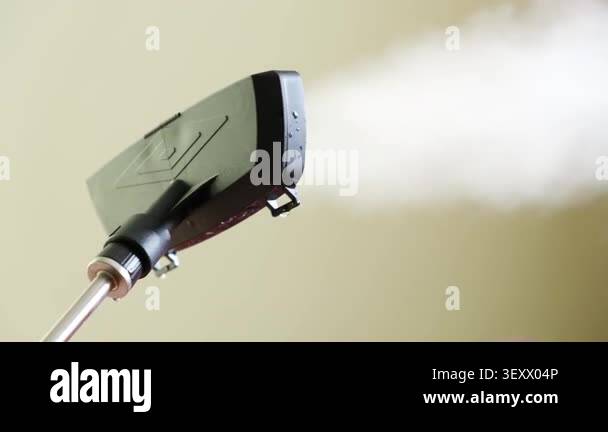 A person uses a steam cleaner inside a home to clean different surfaces ...