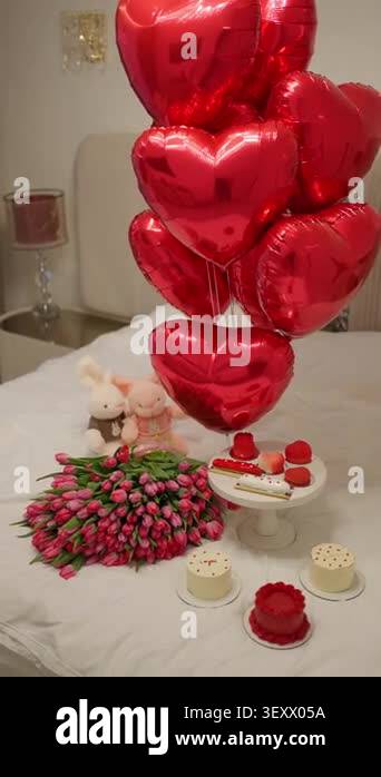 Romantic celebration setup with heart shaped balloons flowers and ...