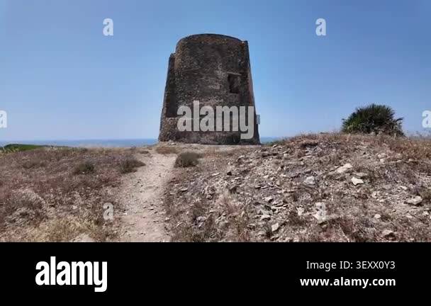 Historic ancient stone watchtower standing on a coastal hill next to a ...