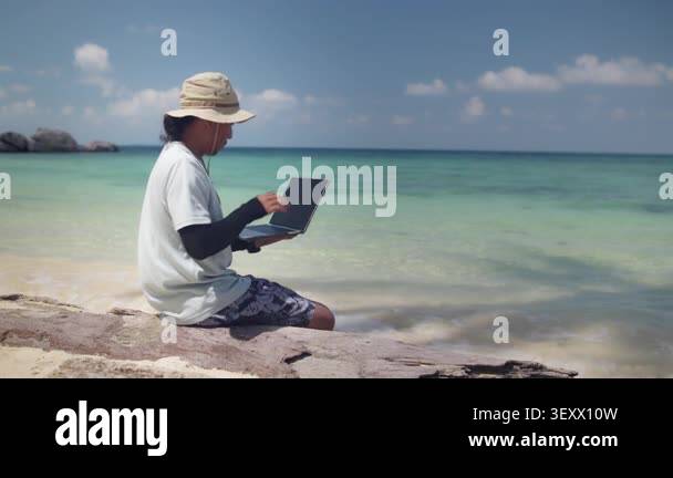 Businessman Working on a Laptop on a Tropical Beach in Casual Wear ...