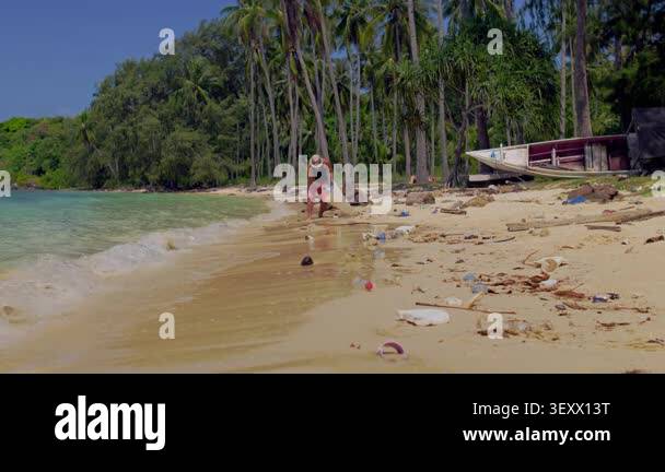 Man Cleaning Plastic Waste from a White Sand Beach Using a Garbage Bag ...