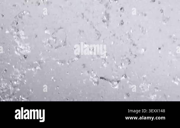 Abstract close-up of falling water droplets creating dynamic splashes ...