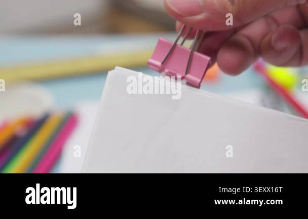 Close-Up of a Hand Securing Papers with a Pink Binder Clip, Perfect for ...