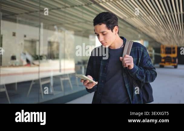 Young hispanic man using mobile phone app in modern office university ...