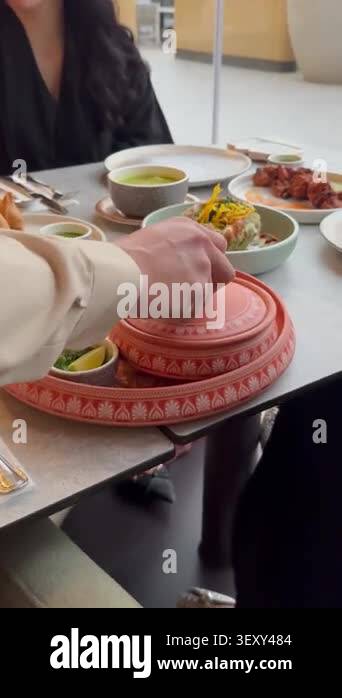 Hand opening a clay pot lid to reveal a delicious Indian meat curry ...