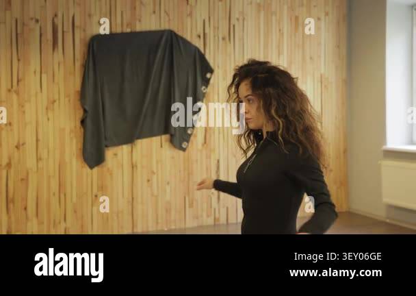 Passionate female dancer with curly hair moving gracefully in a dance ...