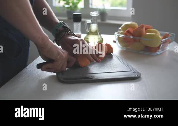 Woman Cutting Raw Sweet Potato In A Close-Up Shot In Home Kitchen Stock ...