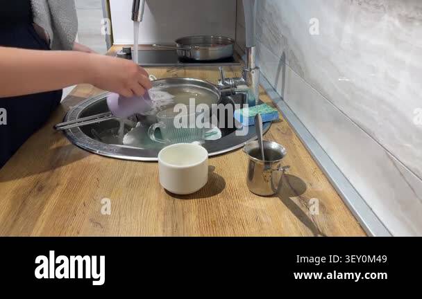Woman hands wash dishes, housewife does household chores and cleaning ...