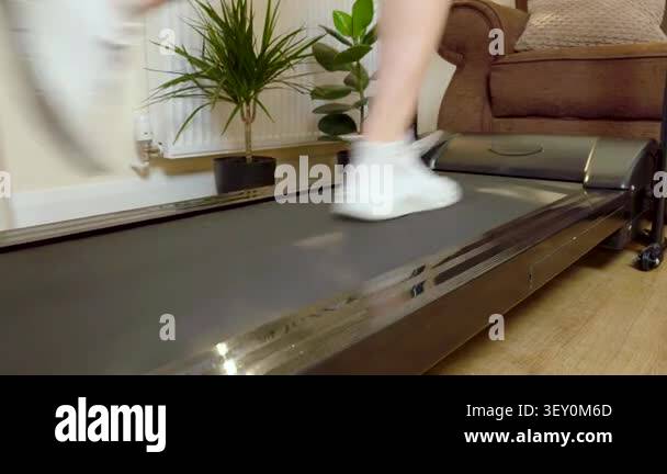 Fast moving legs of unrecognizable runner on treadmill during indoor ...