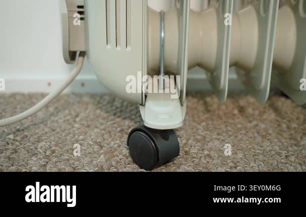 Portable oil filled radiator heater standing on carpet floor. Closeup ...