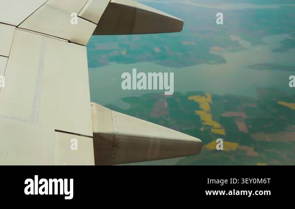 Airliner flying above river delta with visible wing and flap fairings ...