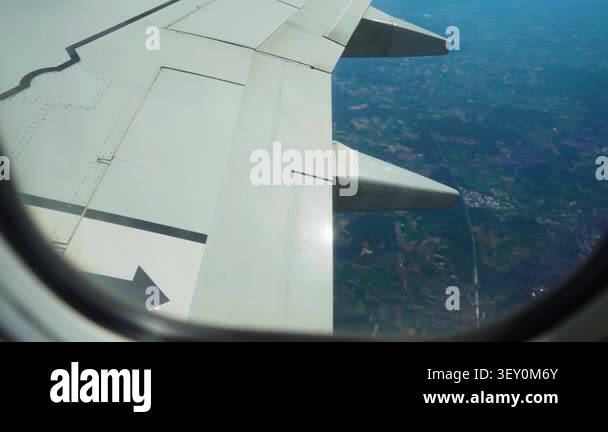 Plane flying above farmland and town clusters divided by roads, view ...