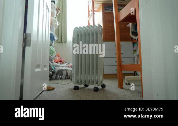 Oil radiator heater warming small bedroom during winter season ...