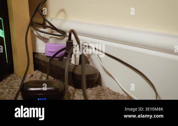 Power strip overloaded with chargers beside gaming PC tower. Multiple ...