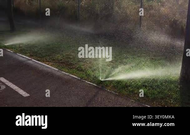 A low-angle, wide shot of an automatic irrigation system in operation ...