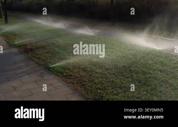 A low-angle, wide shot of an automatic irrigation system in operation ...
