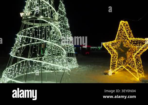 Garlands of lights are hung and twinkle brightly at night. A large star ...