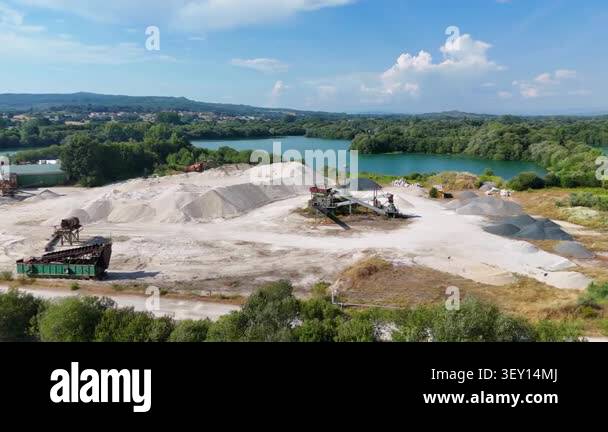 Panoramic aerial view of a gravel pit with heavy machinery. Large piles ...