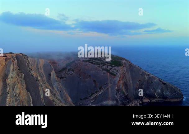 Aerial footage approaching massive coastal cliffs from over the ocean ...