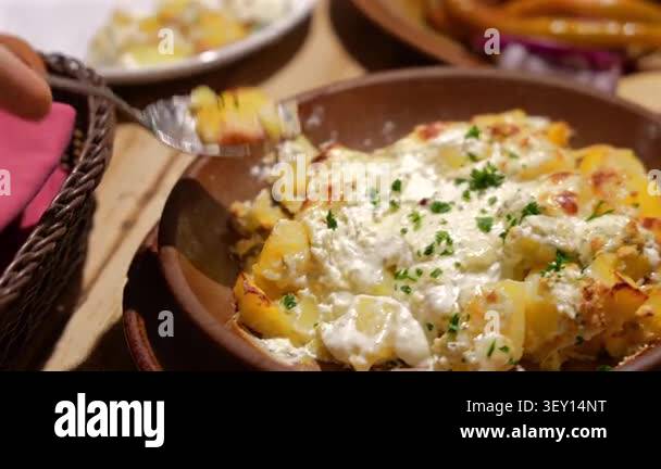 Creamy baked potato casserole with melted cheese and herbs in a rustic ...