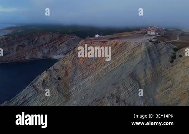 Close aerial approach to towering layered coastal cliffs with a ...