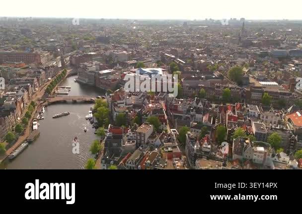 Drone orbits above Amsterdam historic center showcasing winding canals ...