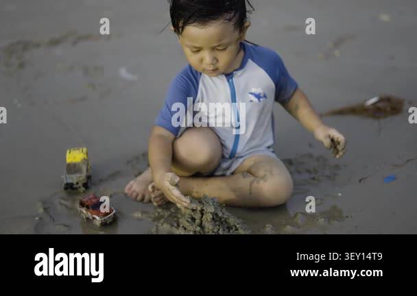 boy playing with a toy on the beach Stock Video Footage - Alamy