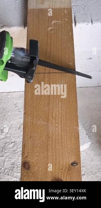 Electric reciprocating saw cutting a wooden beam with a wood blade ...