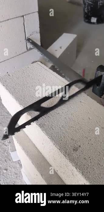 Electric reciprocating saw with an aerated concrete blade cutting a gas ...