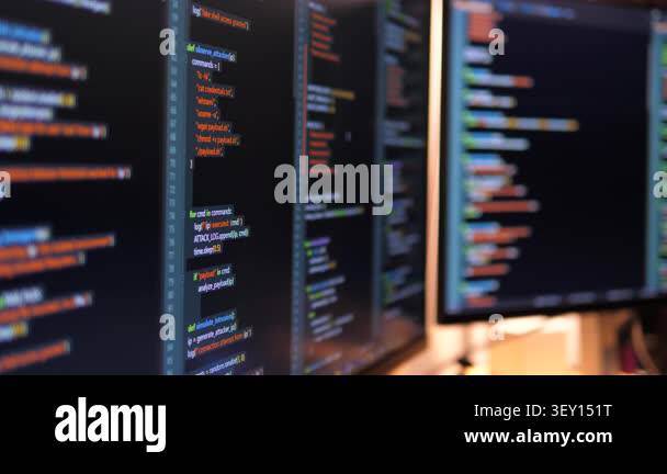 Close up computer monitors displaying fictional programming code and ...