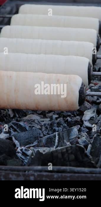 Preparation of the Hungarian traditional kurtos kalacs roasted over ...