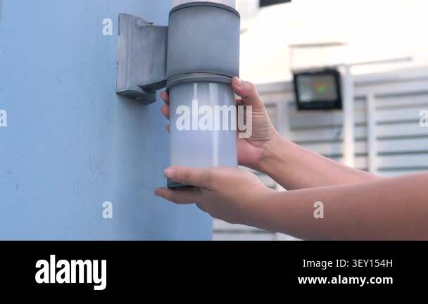 Close up shot of a person hand replacing or installing an energy-saving ...