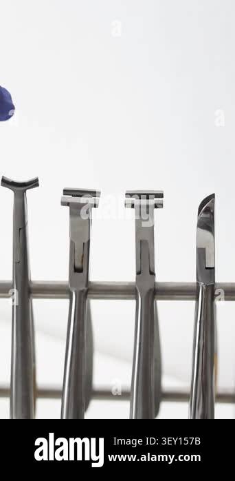 Gloved dentist hand selecting orthodontic tool in clinical dental ...