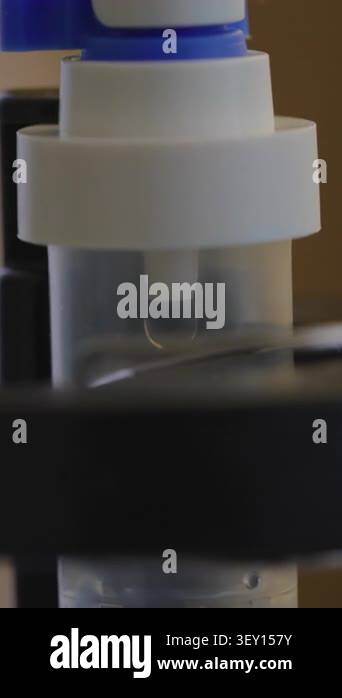Macro close up of IV infusion equipment capturing a liquid drop forming ...