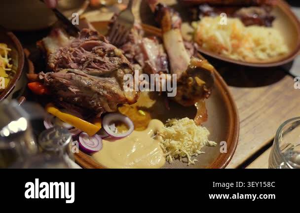Traditional Czech roasted pork knuckle carved with knife and fork ...